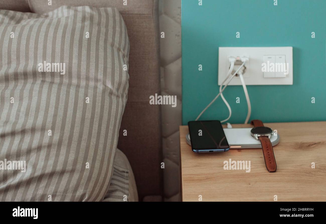 Bedside charging for phone and smart watch Stock Photo - Alamy