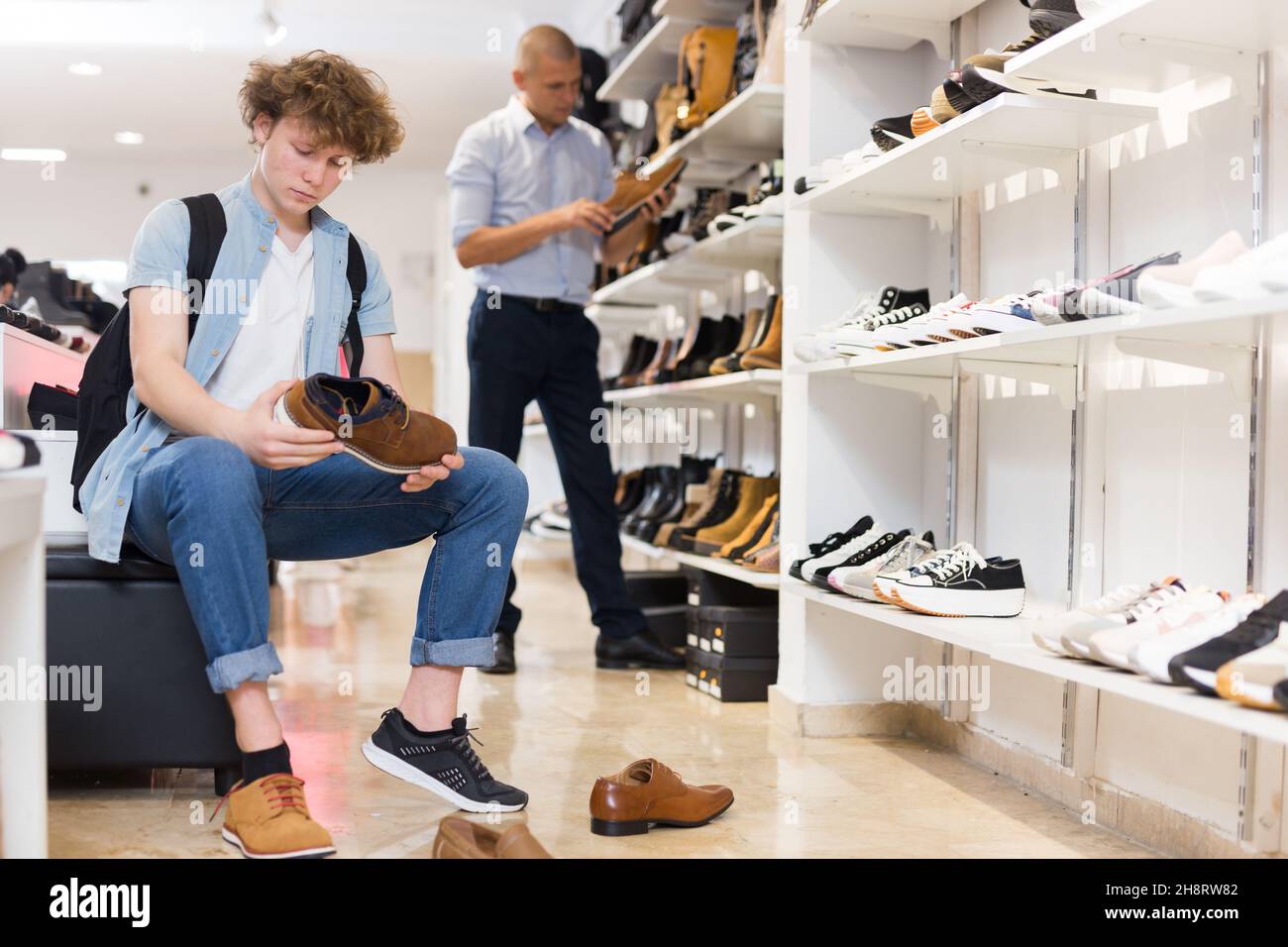 Teen boy trying on classic shoes at shoe store Stock Photo - Alamy