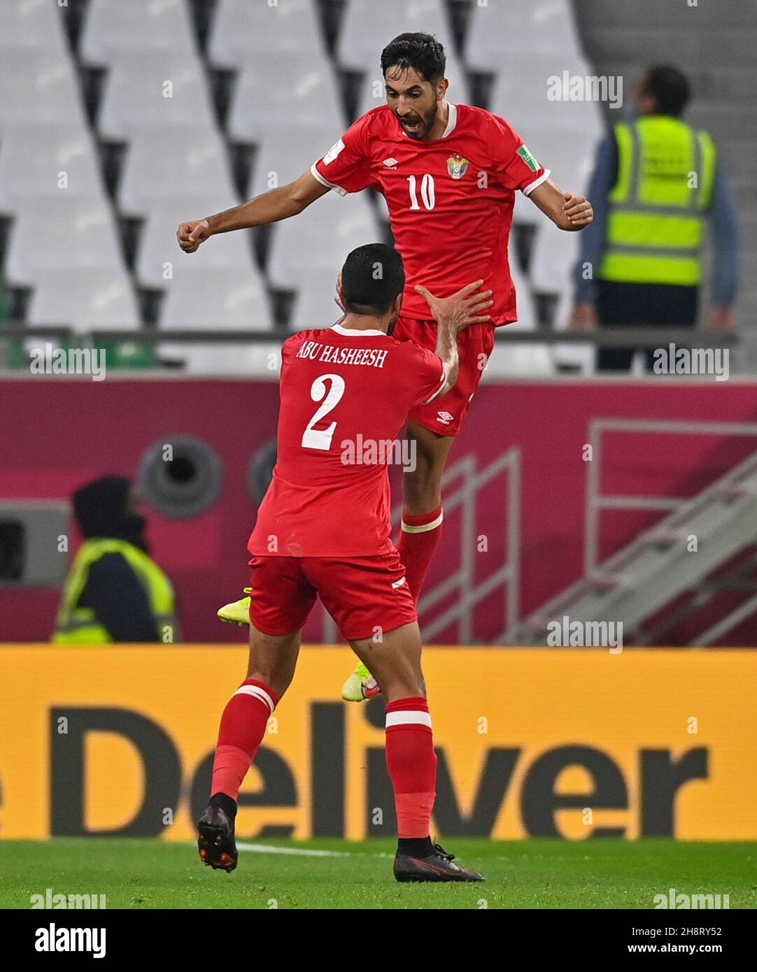 Al Rayyan, Qatar. 1st Dec, 2021. Yazan Alnaimat (top) of Jordan ...