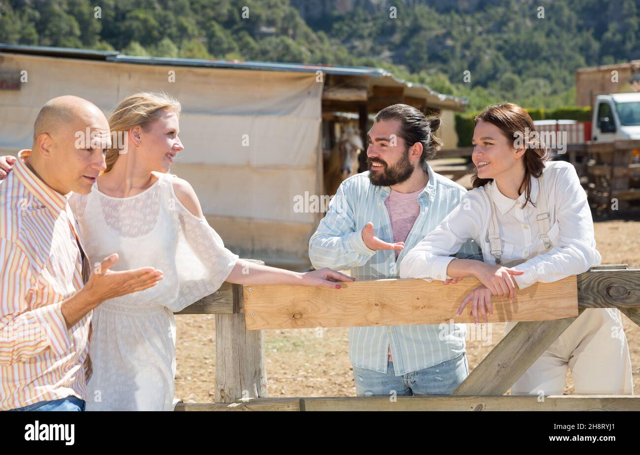 Happy friends chatting on rustic farm background Stock Photo - Alamy