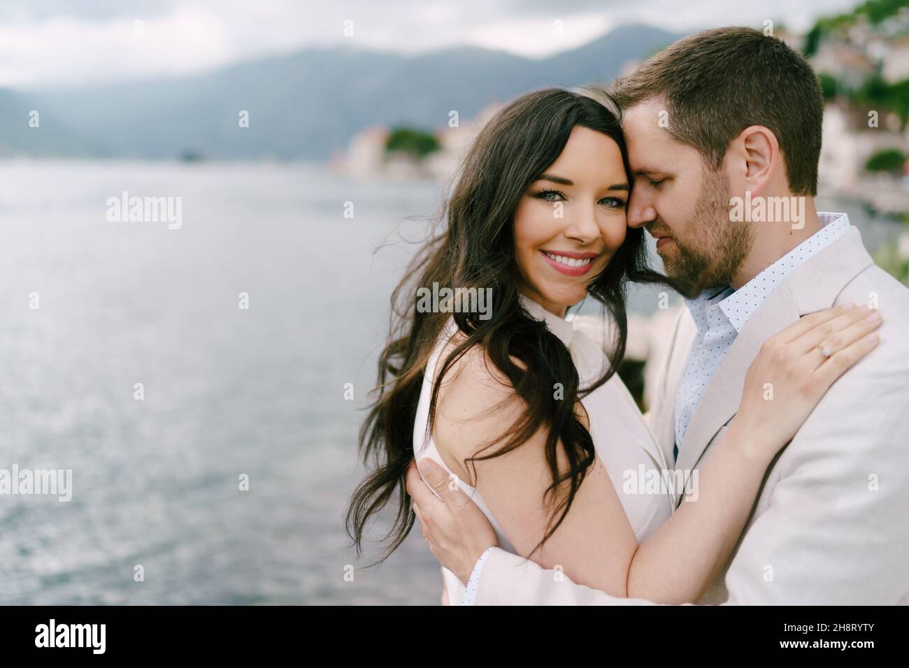 Man hugs smiling woman by the sea. Portrait Stock Photo - Alamy