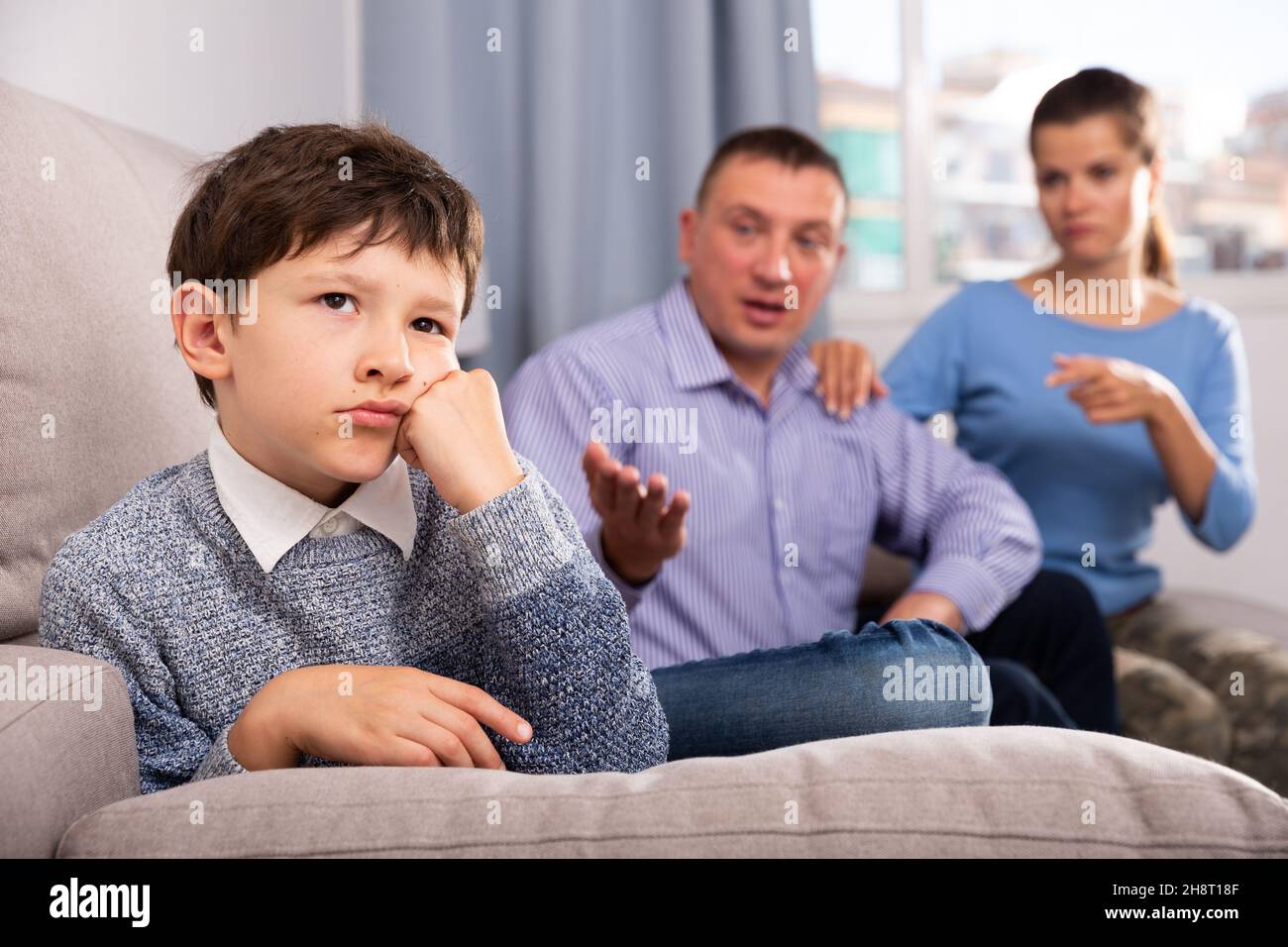 Frowning boy with mother and father berating him Stock Photo - Alamy