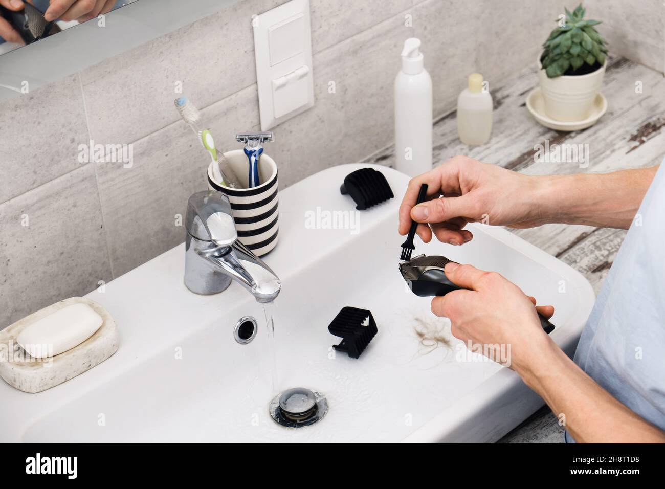 Man cleaning electronic shaving razor in sink, male self care and ...