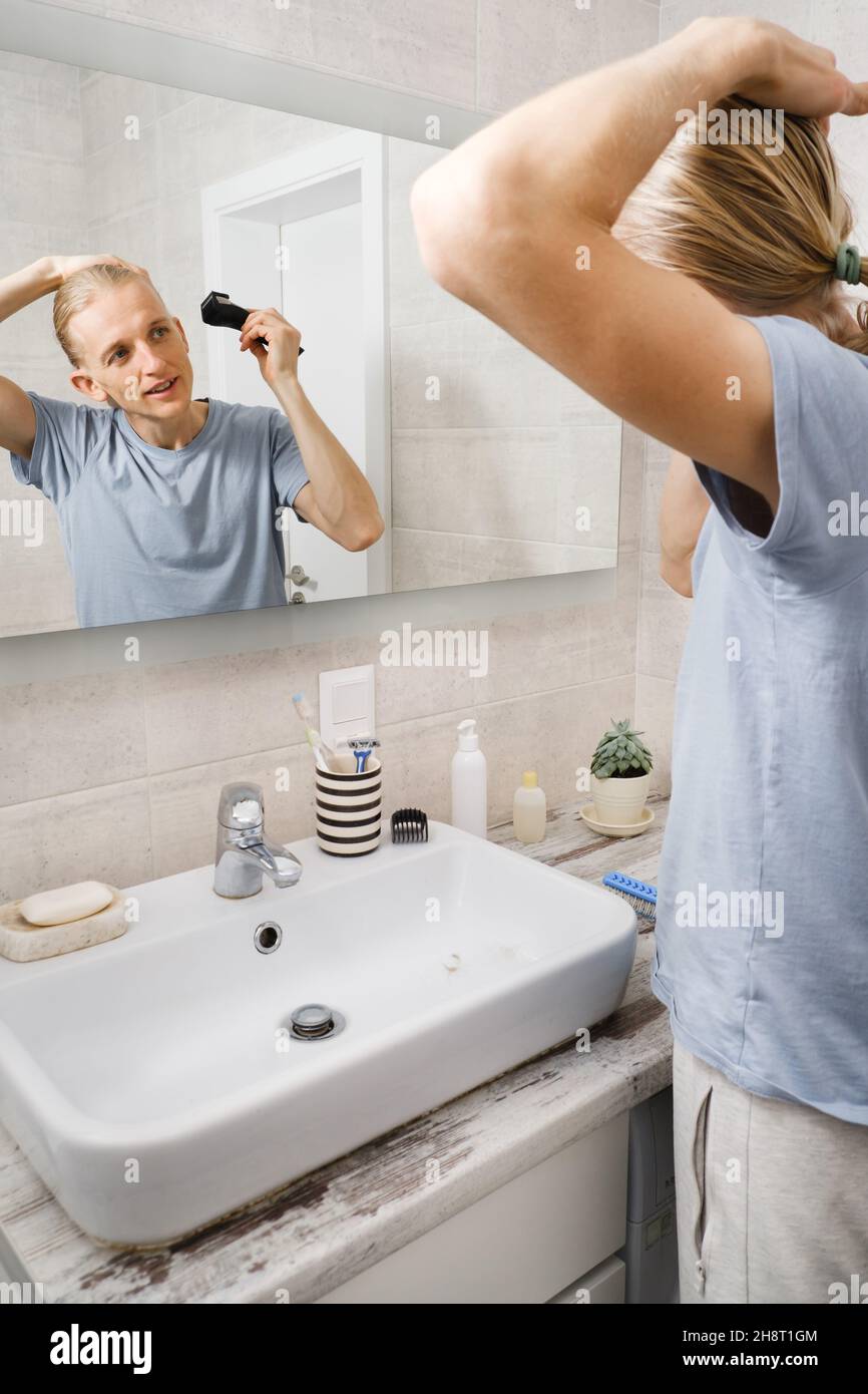 Man shaving whiskers hair by himself, self haircut at home in front of ...