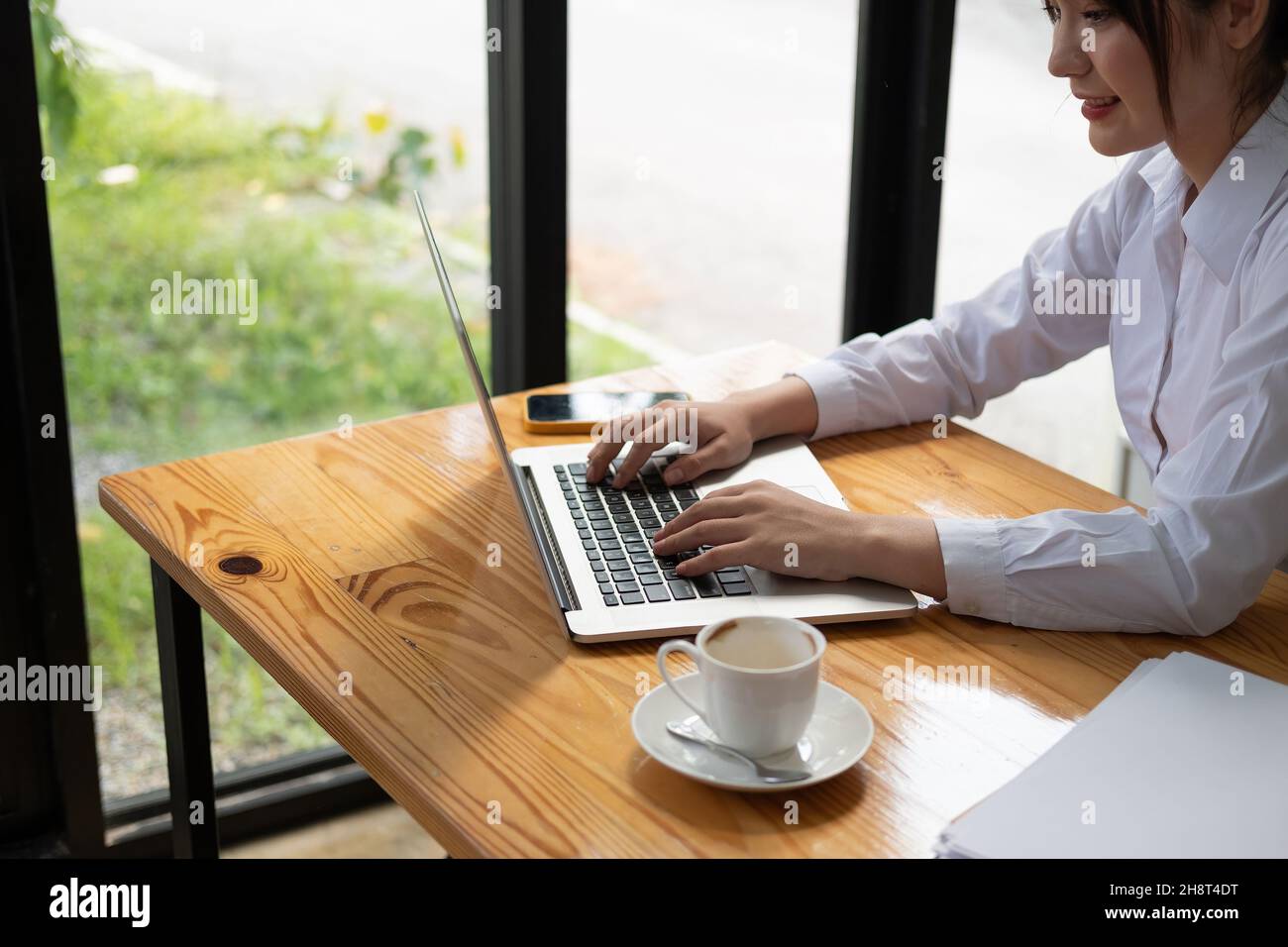 Smiling young asian businesswoman using computer at office workplace ...