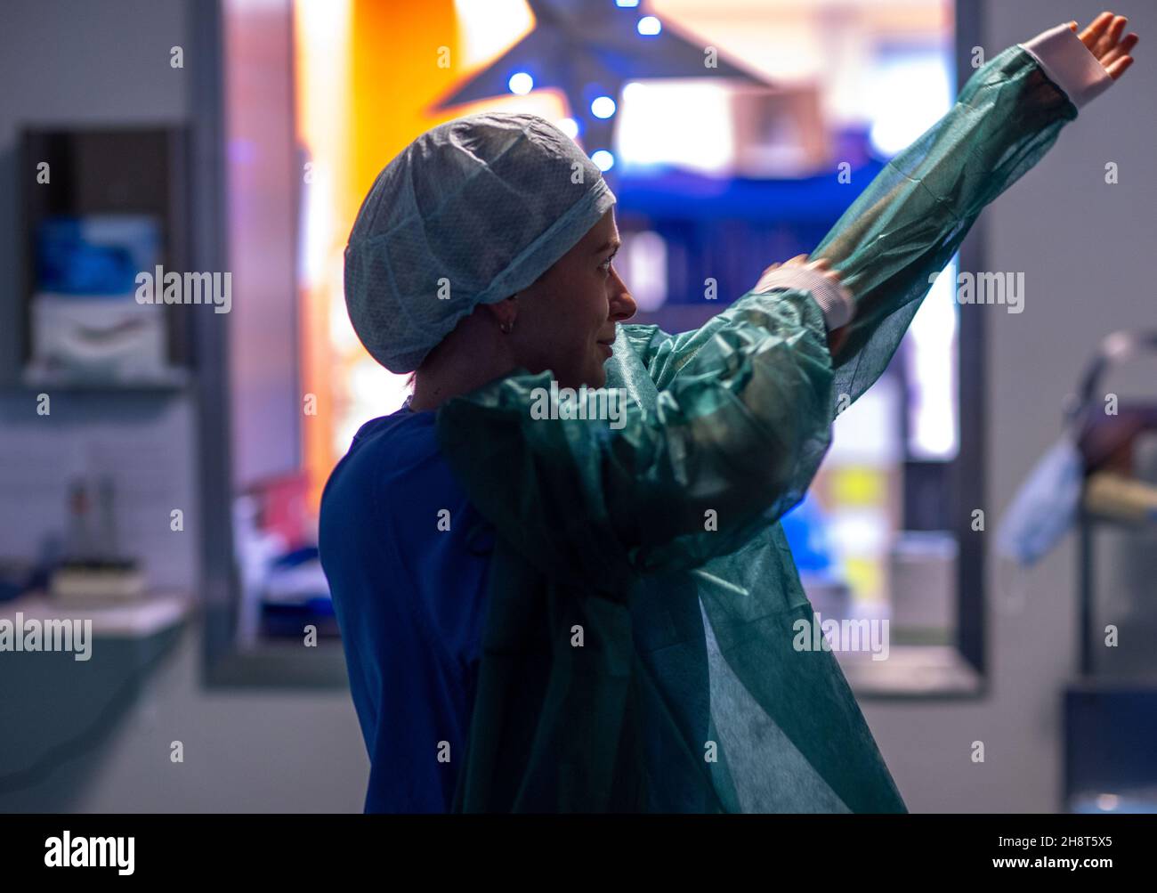 Rostock, Germany. 30th Nov, 2021. Nurse Anne-Marie Kalinowski puts on ...