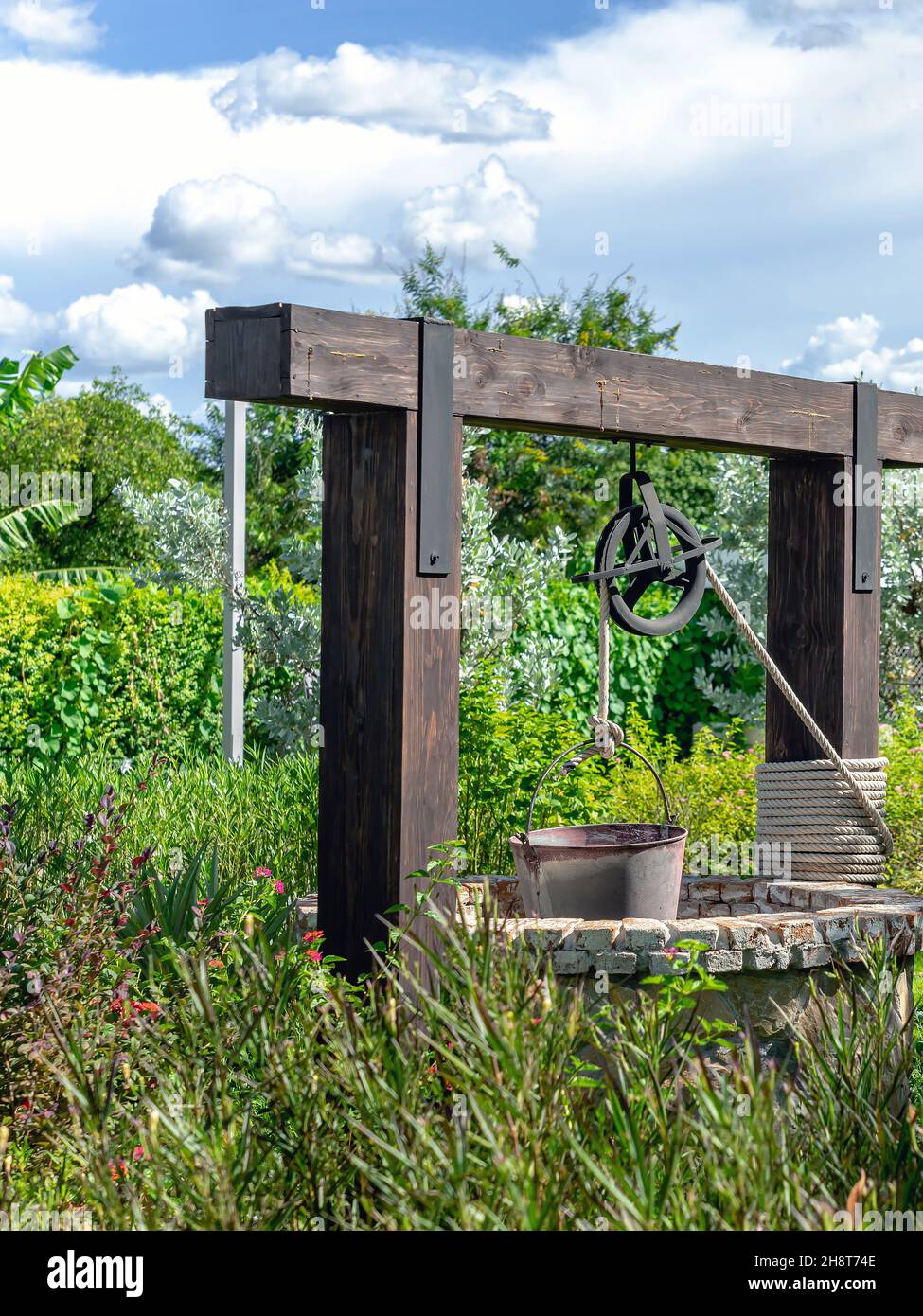 Beautiful artesian well made by stones and wheel pulley with metal ...