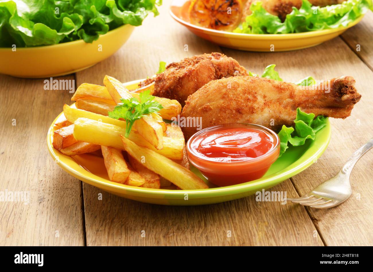Fried chicken legs with french fries on the table Stock Photo - Alamy