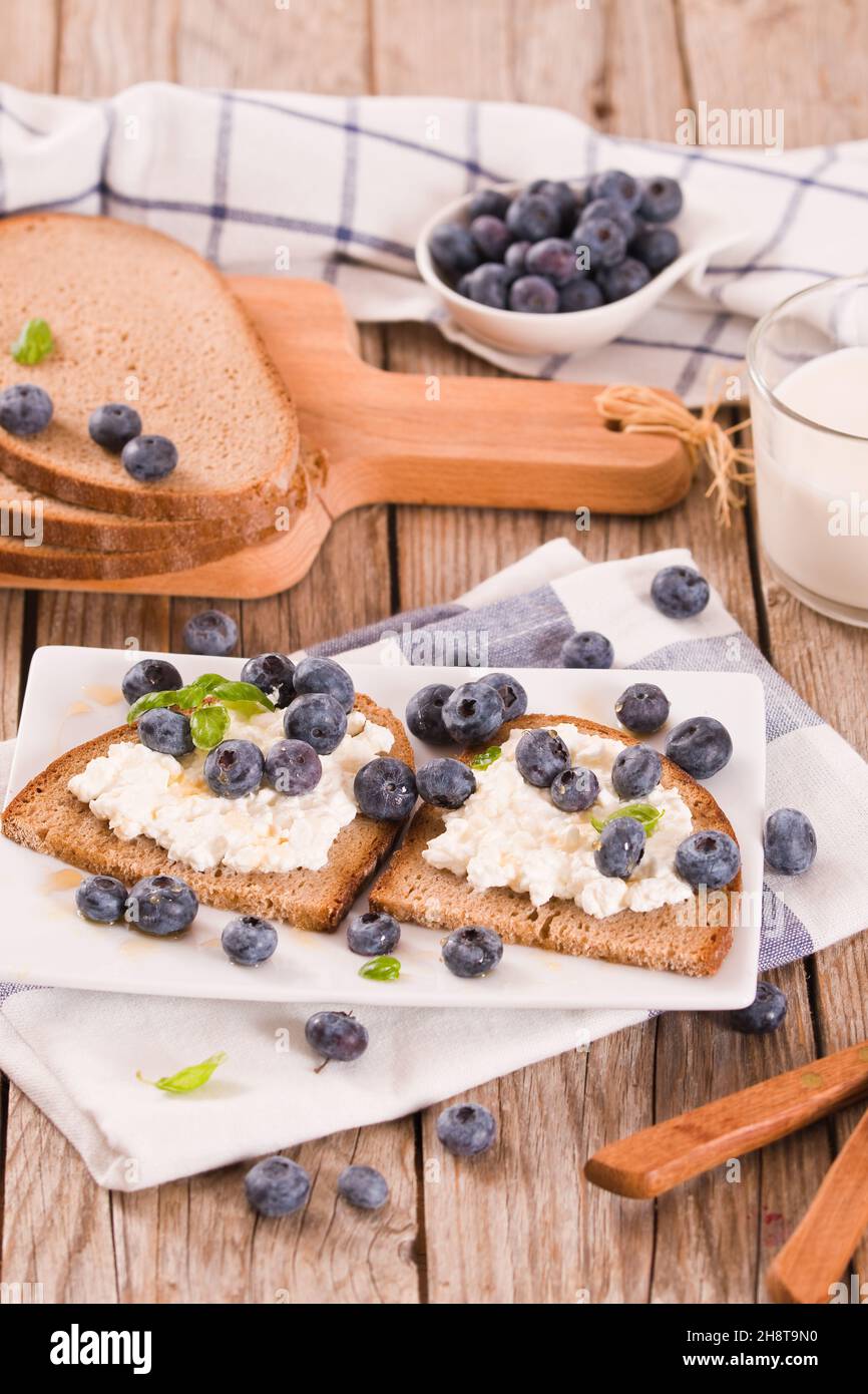Rye bread with cottage cheese, blueberries and honey Stock Photo - Alamy