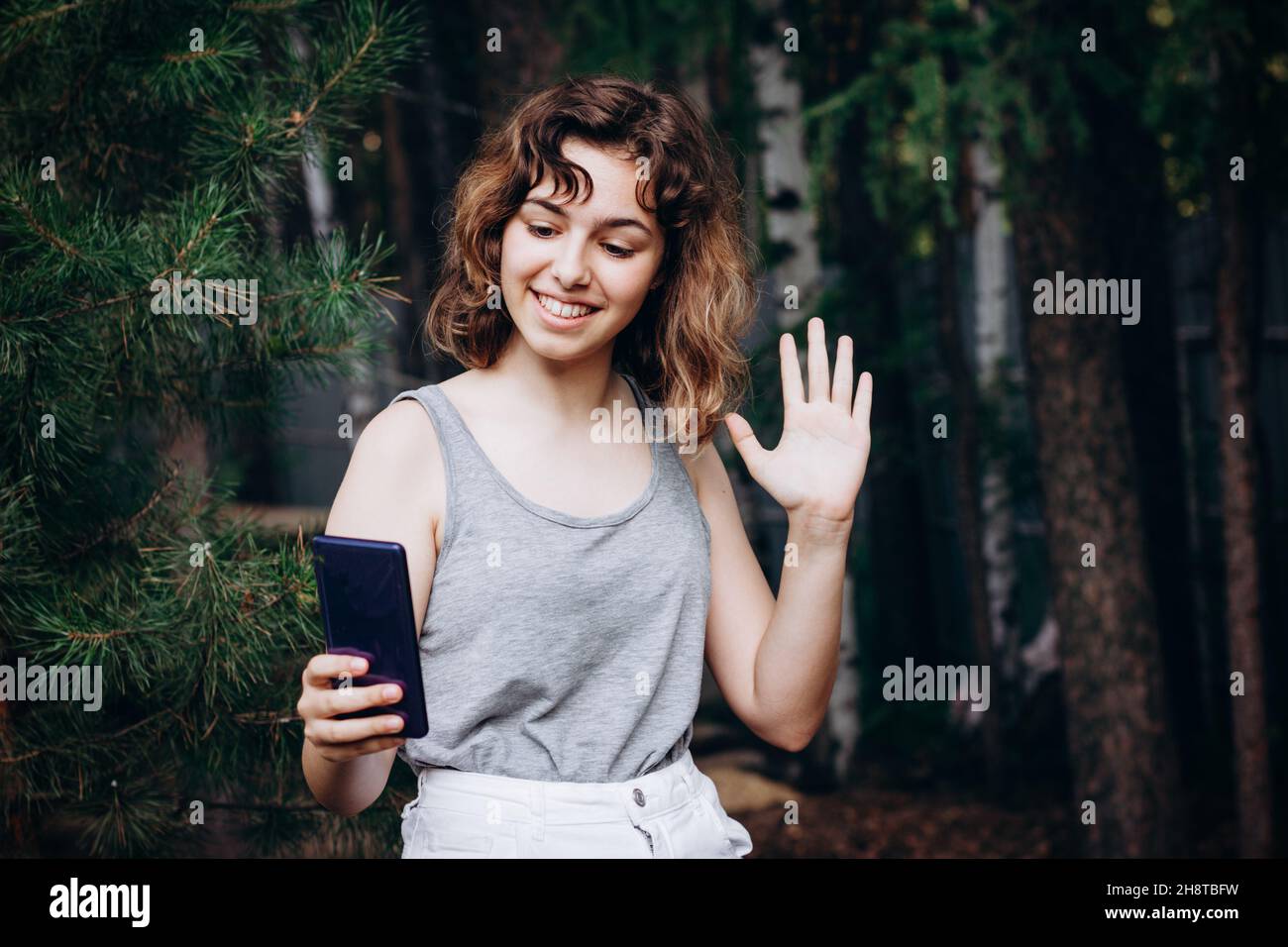 Beautiful teenager girl talking with friends by video call at the ...