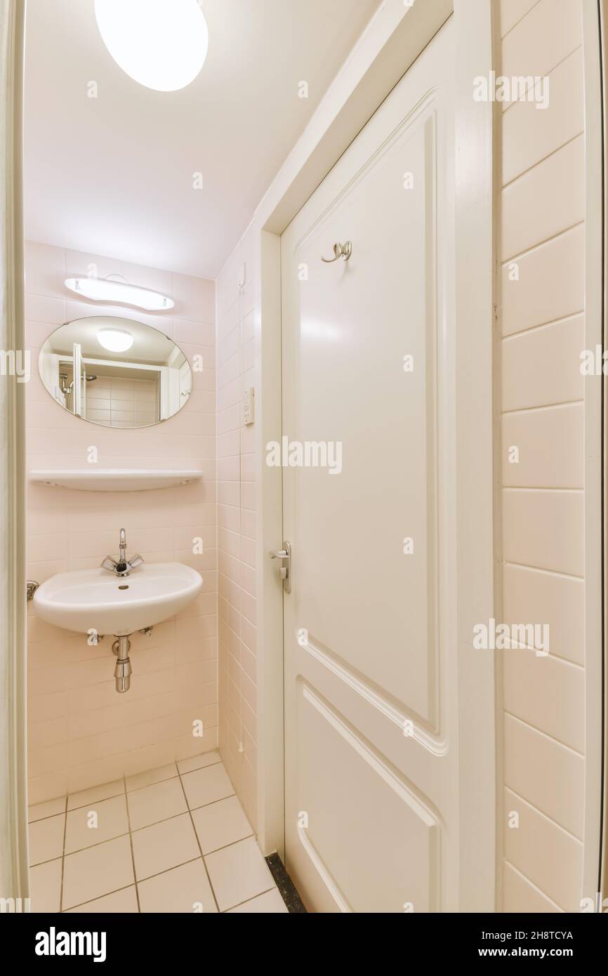 Sink with tap hanging on tiled wall under mirror in contemporary ...