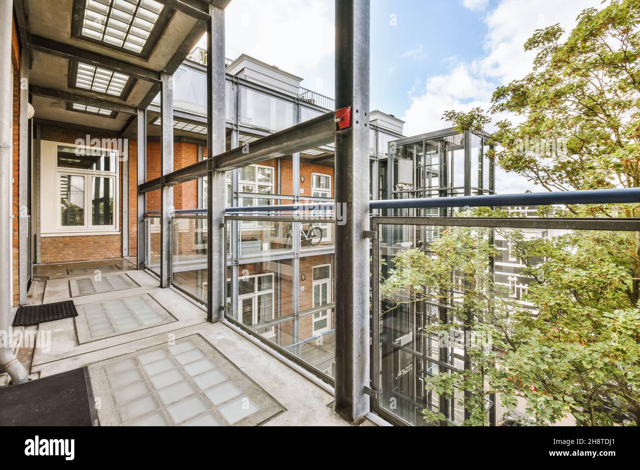 Attractive long narrow balcony with glass railings Stock Photo - Alamy