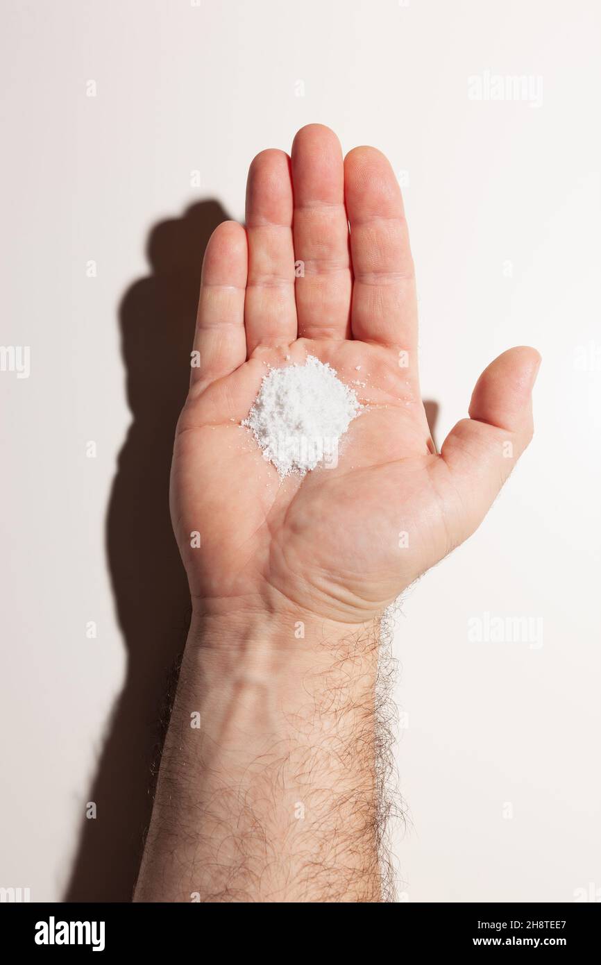 White medicine powder in outstretched palm of male hand, on white ...