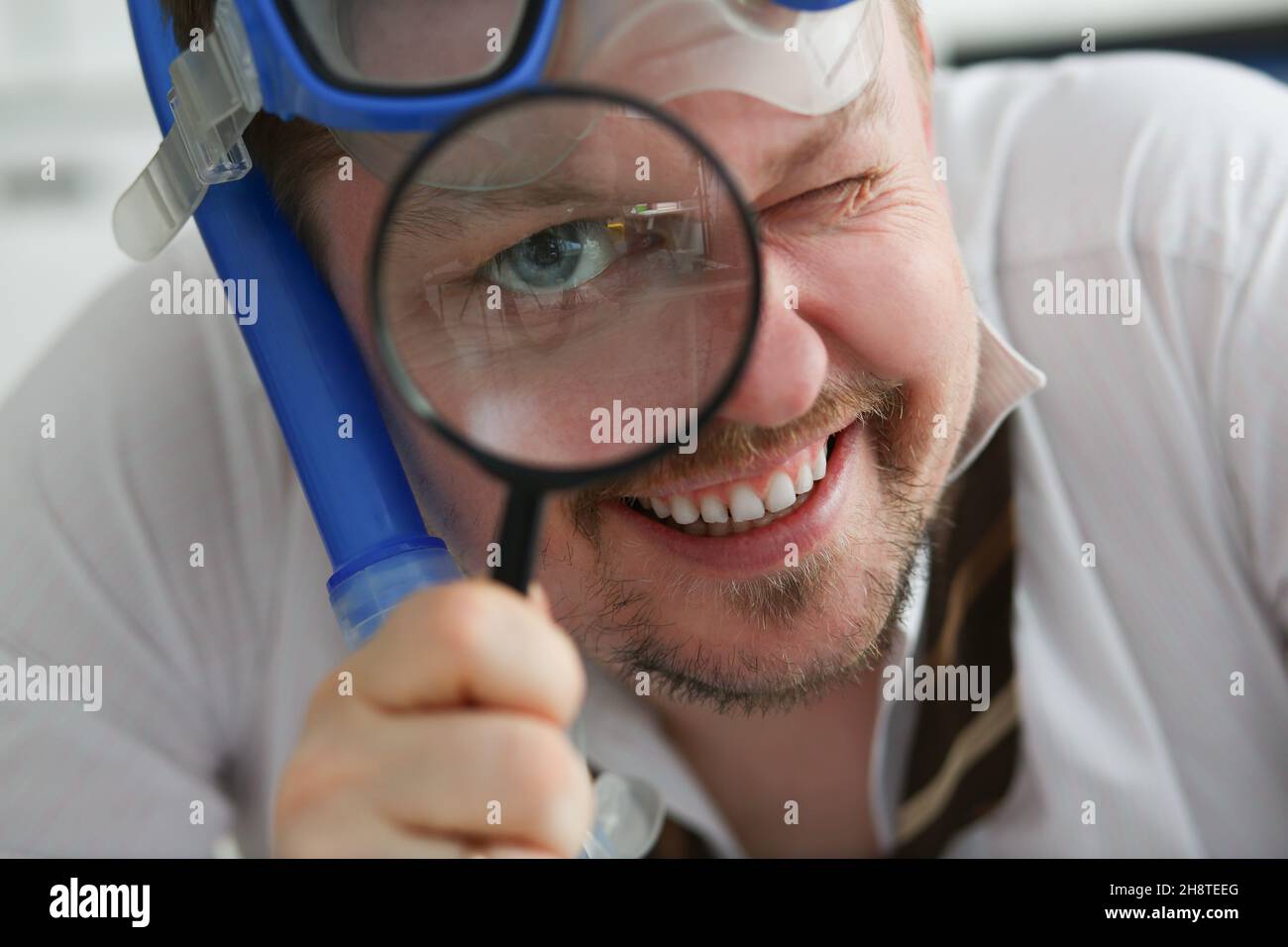 A man looks through a magnifying glass, close-up Stock Photo - Alamy