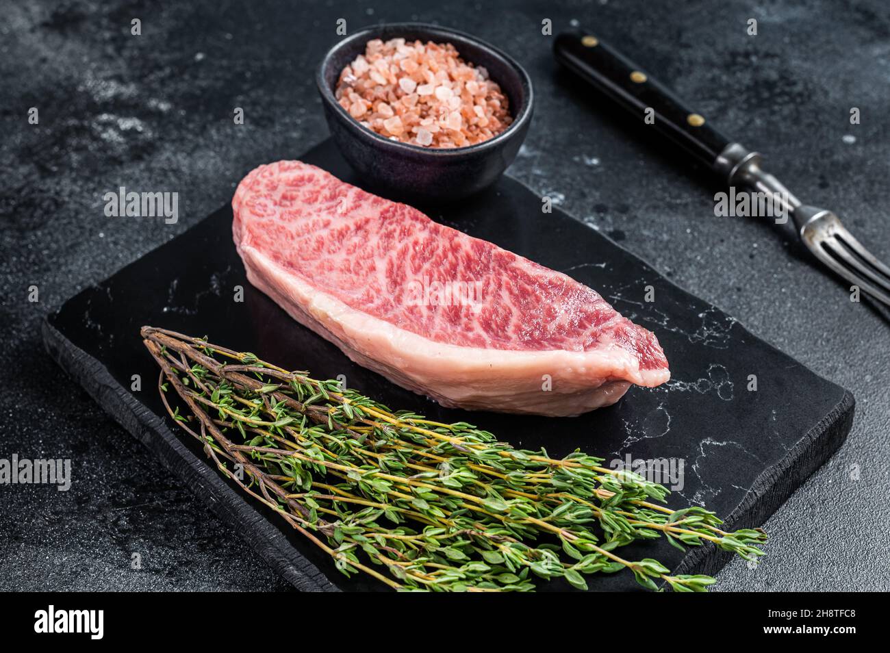 Wagyu raw sirloin steak, kobe beef meat on marble board. Black ...
