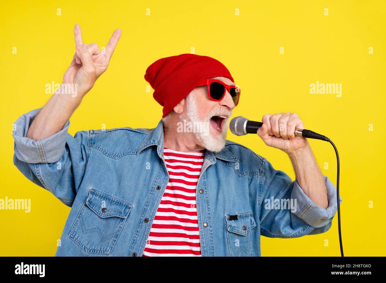Portrait of attractive cheery funky talented grey-haired man singing ...