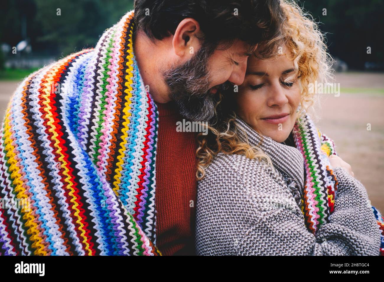 Romantic adult couple stay together with feeling and love covered by a ...