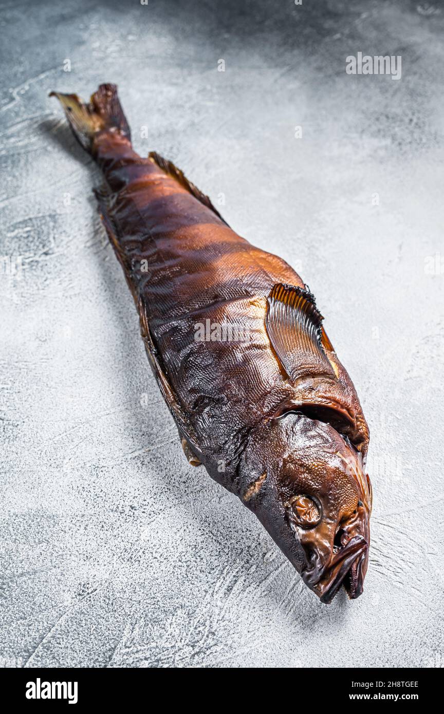 Hot smoked whole fish on kitchen table. White background. Top view ...