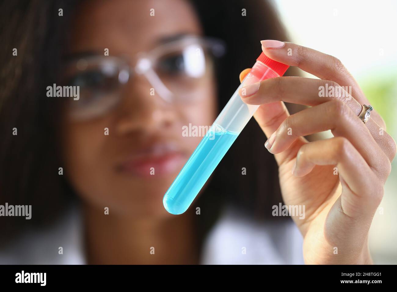 Dark-skinned female laboratory assistant holding a test tube Stock ...