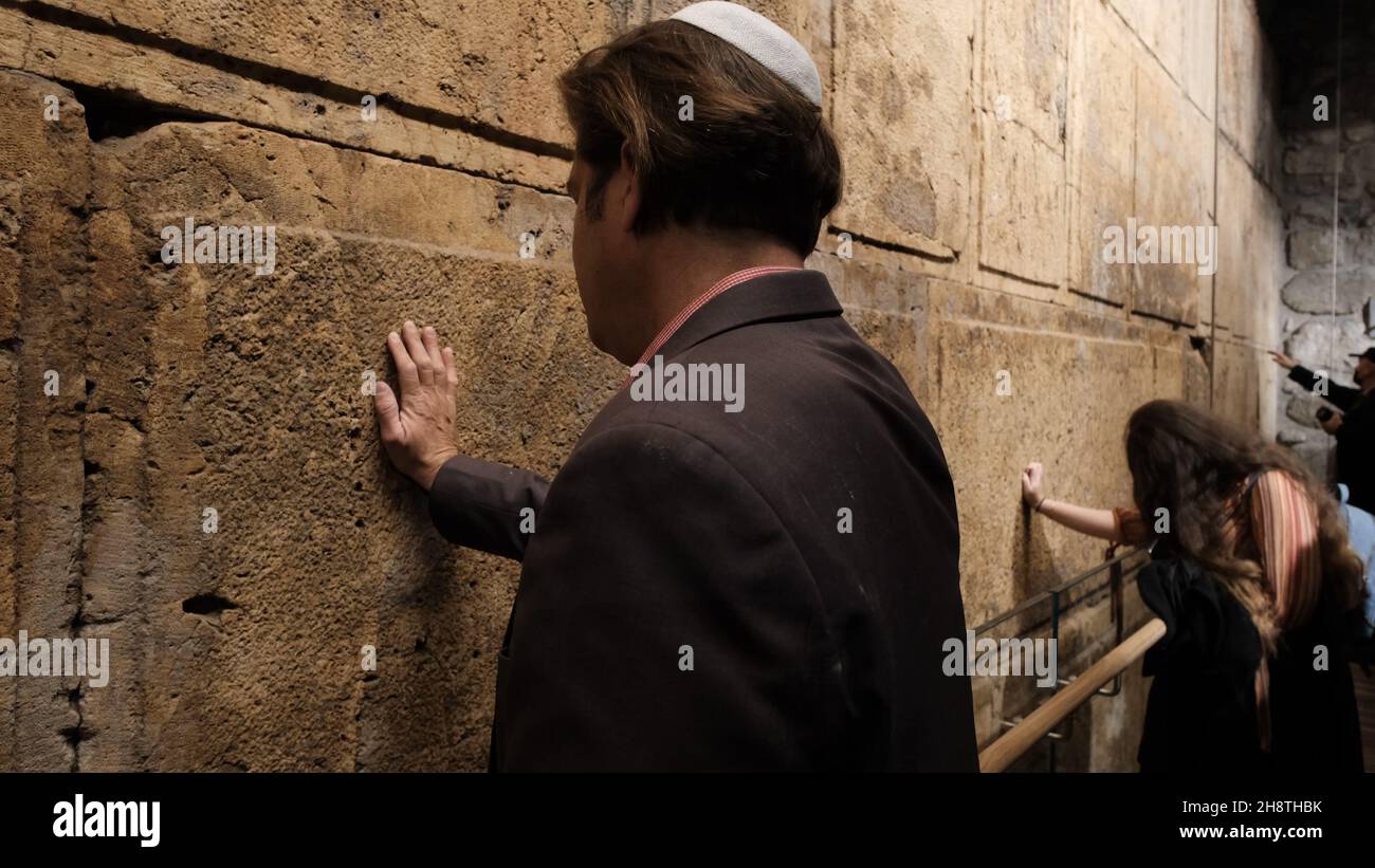 A religious Jew prays in front of recently excavated large portions of ...