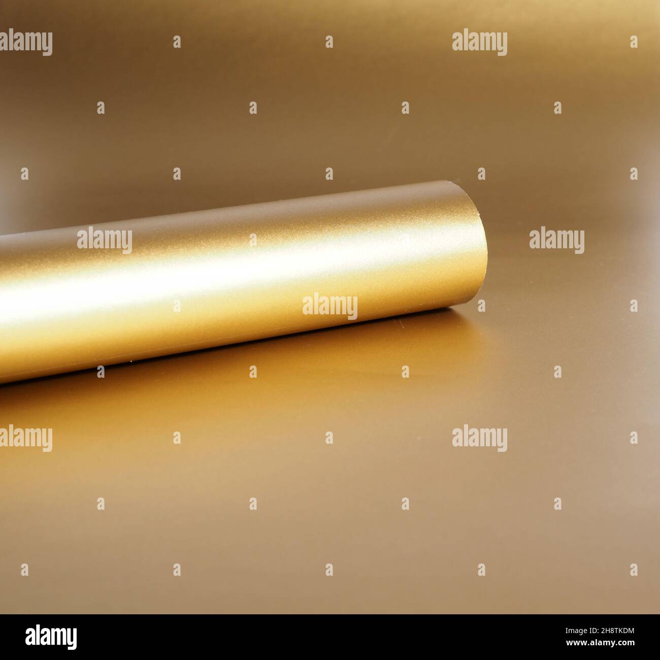 Gold paper rolled up in a tube, in a circle, abstract background for ...