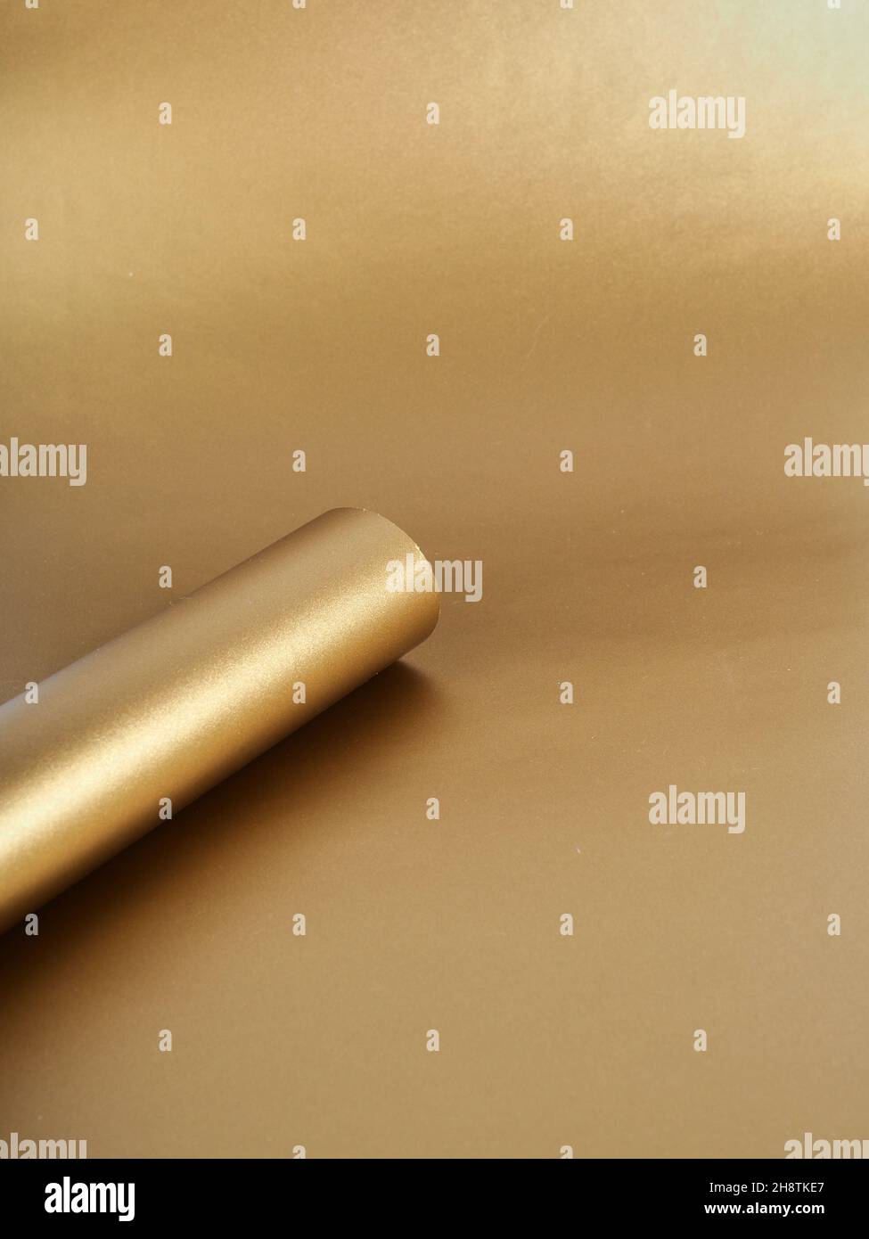 Gold paper rolled up in a tube, in a circle, abstract background for ...