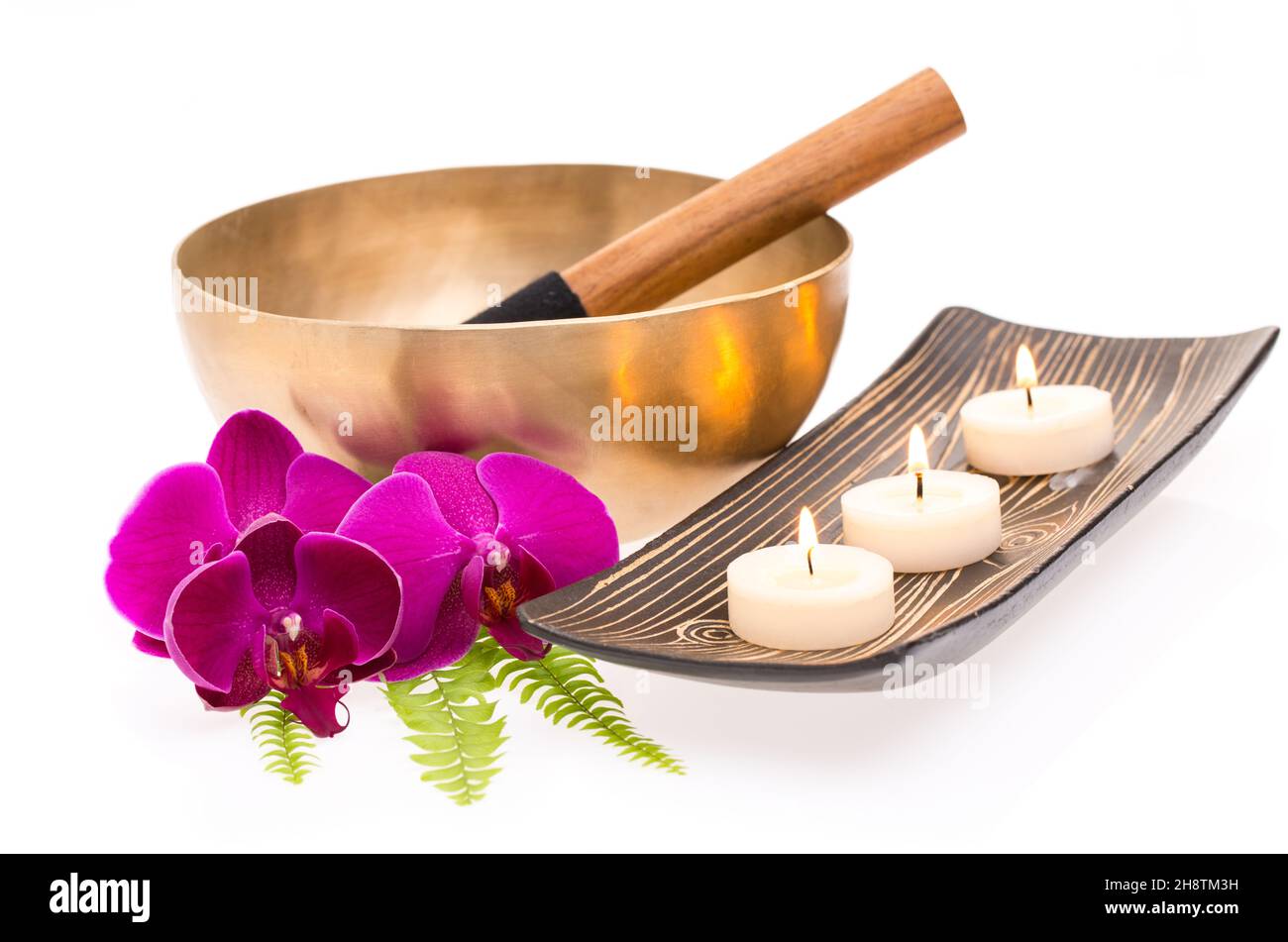 Singing bowl with fern, orchid and candles isolated on white background ...