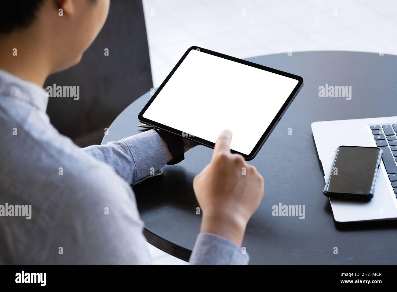 A man holding a tablet with a blank white screen. The blank space on ...