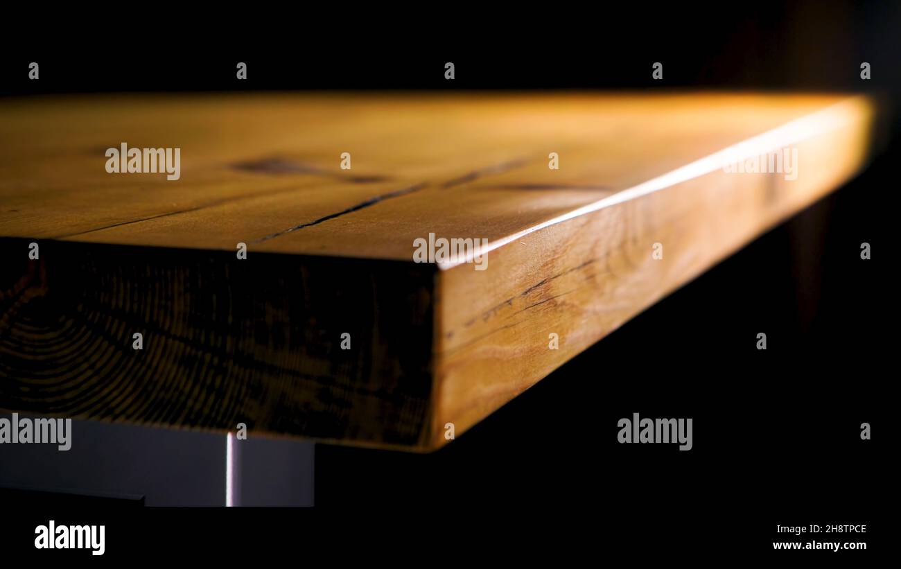 Close-up of edge of wooden table on dark background. Stock footage ...