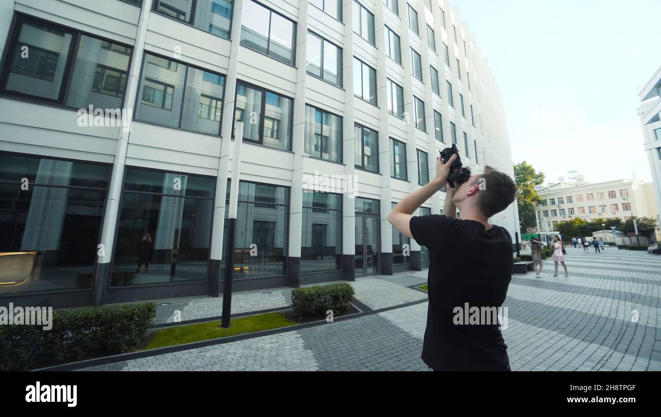 Photographer takes pictures of city's modern architecture. Action ...