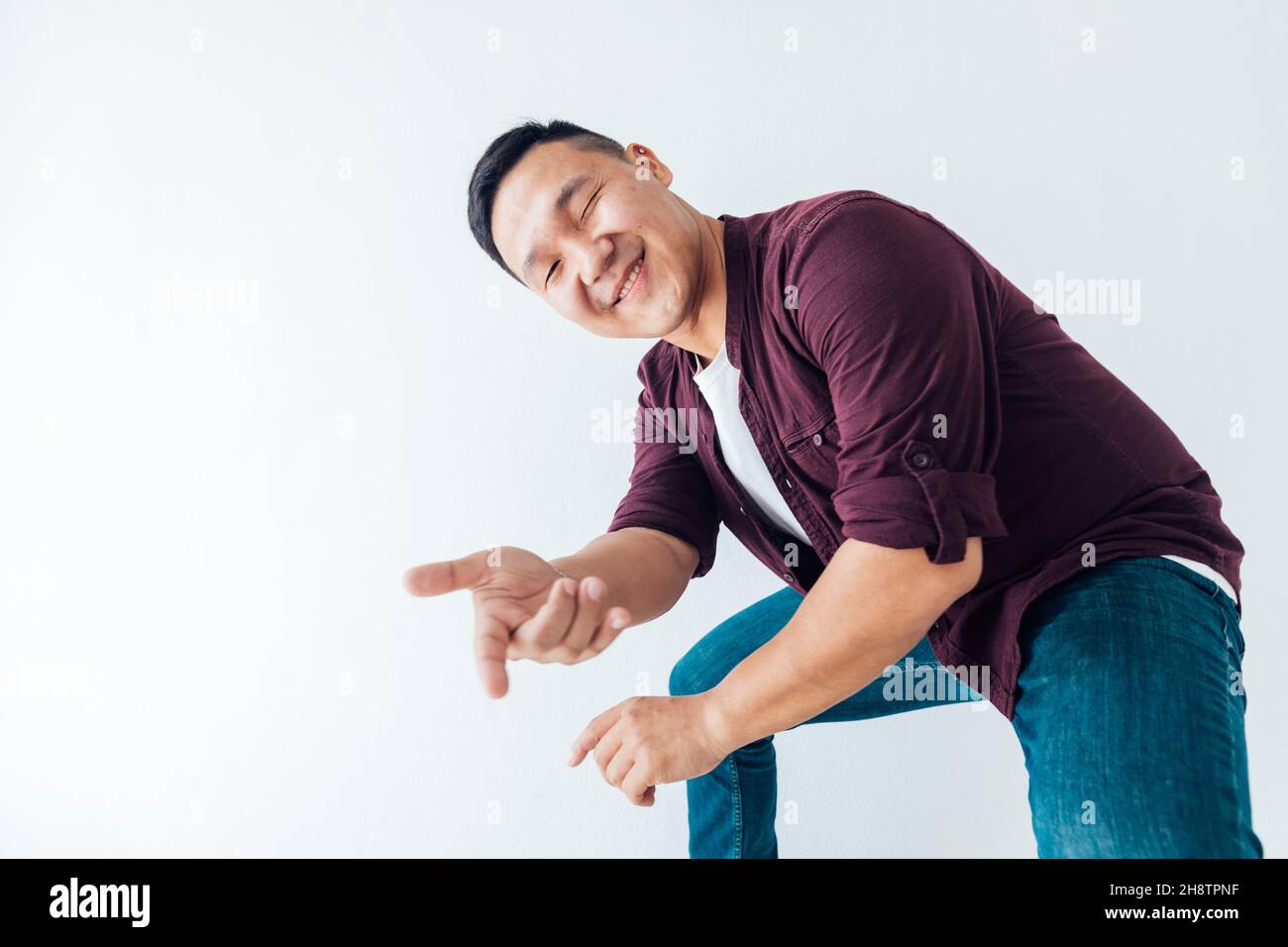 Asian man dancing to music alone at home Stock Photo - Alamy