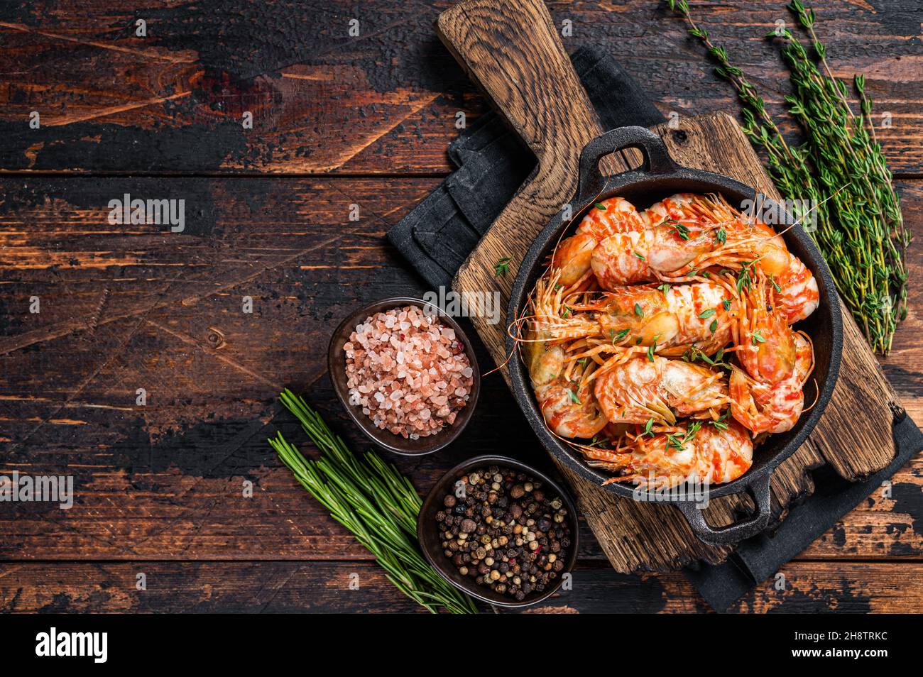 Cooking Greenland Shrimps Prawns in a pan with thyme and rosemary. Dark ...