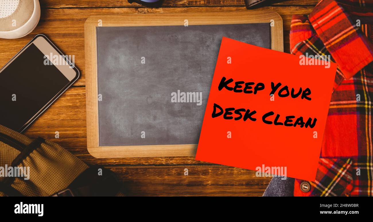 Image of keep your desk clean text on memo note over chalkboard on desk ...