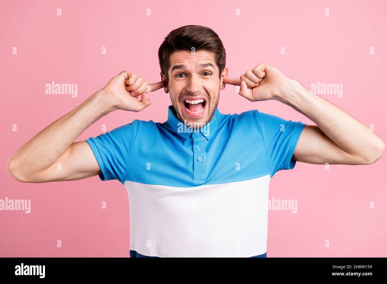 Photo of young angry mad male cover ears heaving headache suffering ...