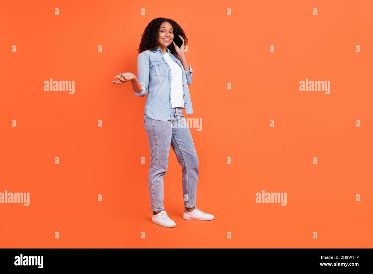 Full body photo of unsure young brunette lady talk telephone wear jeans ...