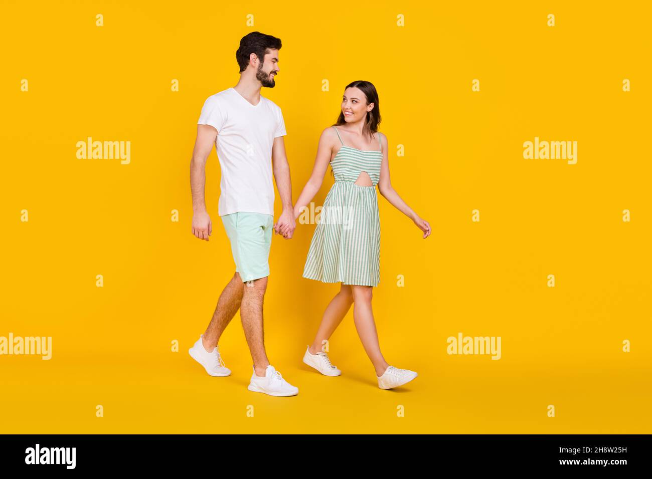 Photo of charming couple hold hands enjoy carefree steps wear casual ...