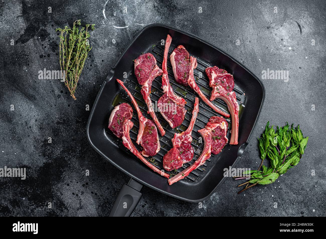 Ready for cooking Raw lamb, mutton chops steaks in a pan with herbs ...