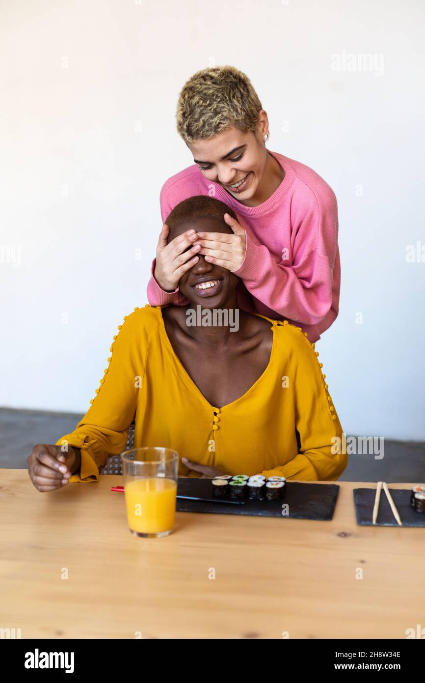 Guess who Beautiful woman covering eyes of her female friend and ...