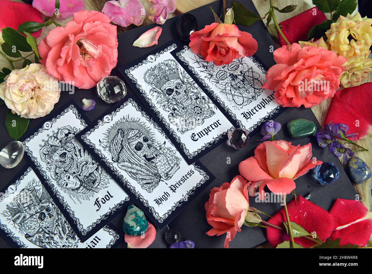Still life with tarot cards with black and white skullls, roses and ...