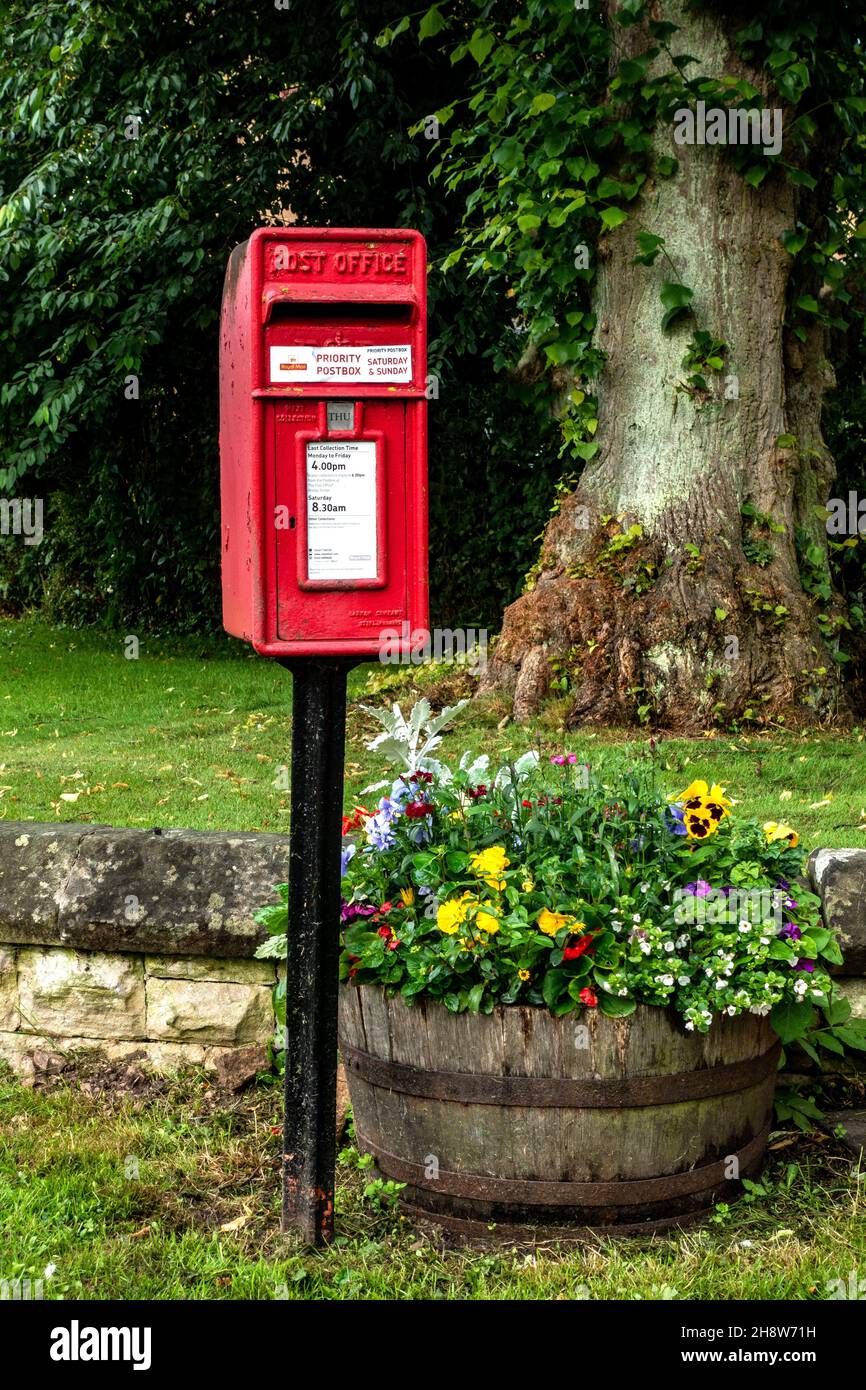 English iconic red post box in pretty village Stock Photo - Alamy
