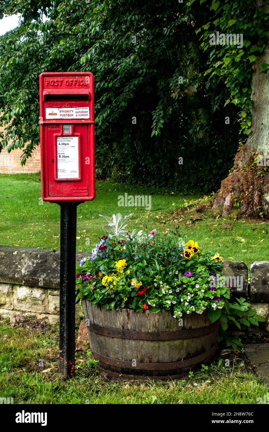 English iconic red post box in pretty village Stock Photo - Alamy