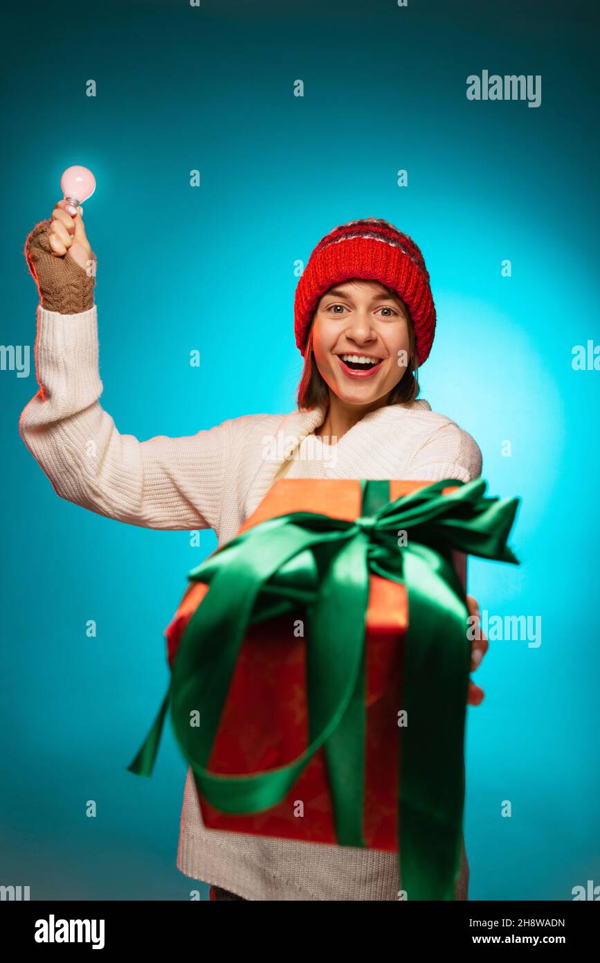 Giving presents. Young happy girl with big present box posing isolated ...