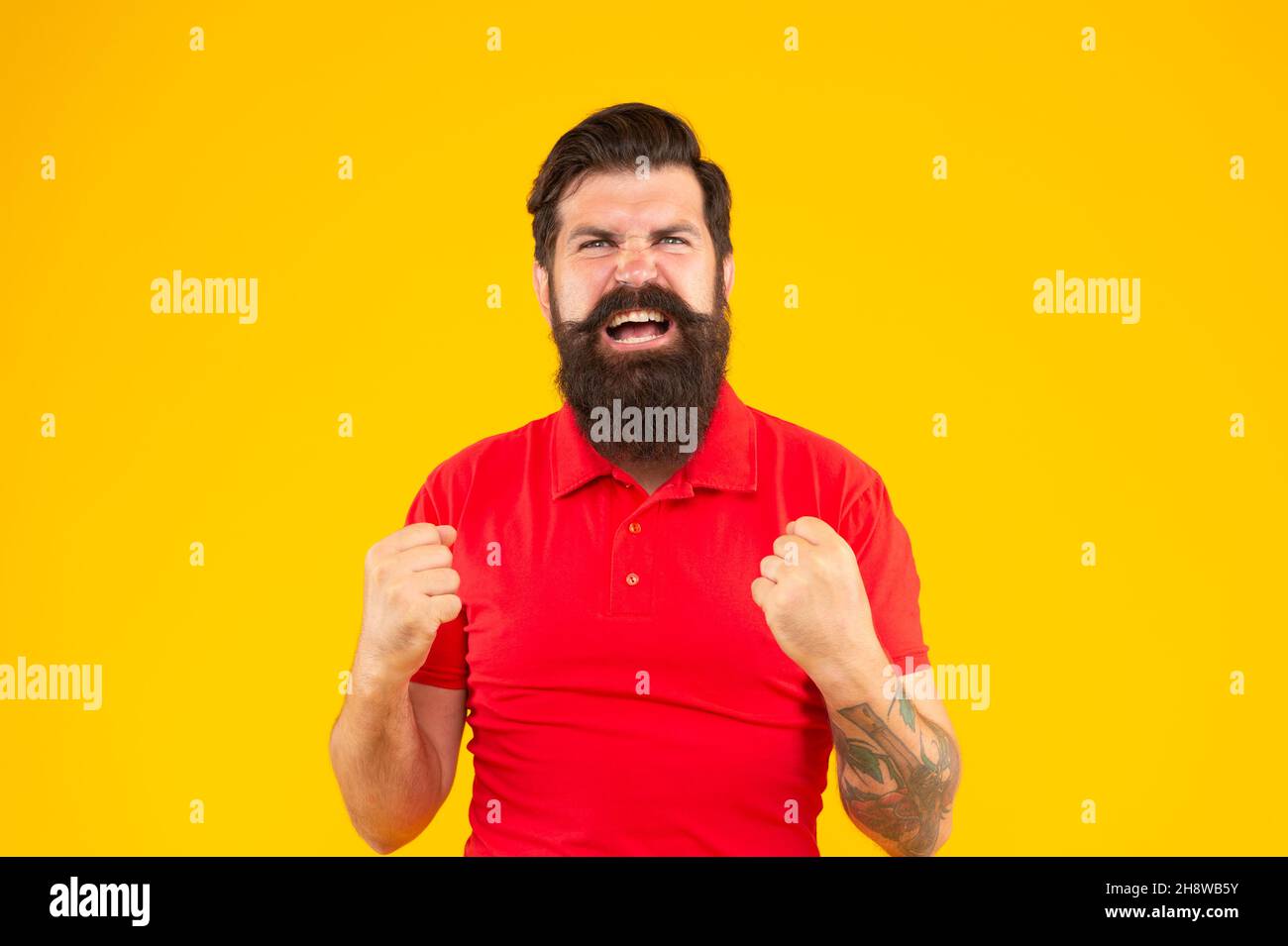 aggressive hipster male with beard on yellow background, anger Stock ...