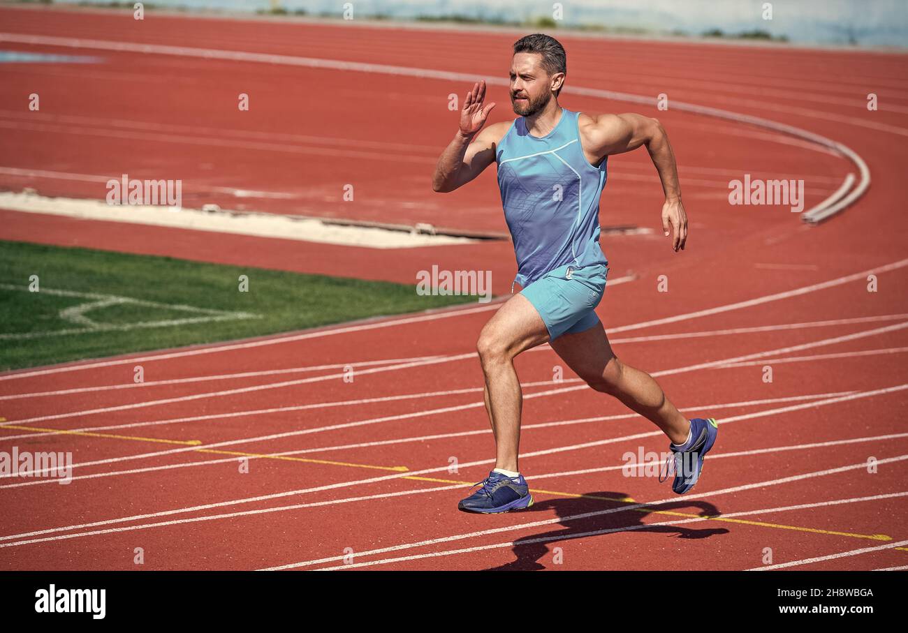 Dynamic movement of male runner on running track, run Stock Photo - Alamy