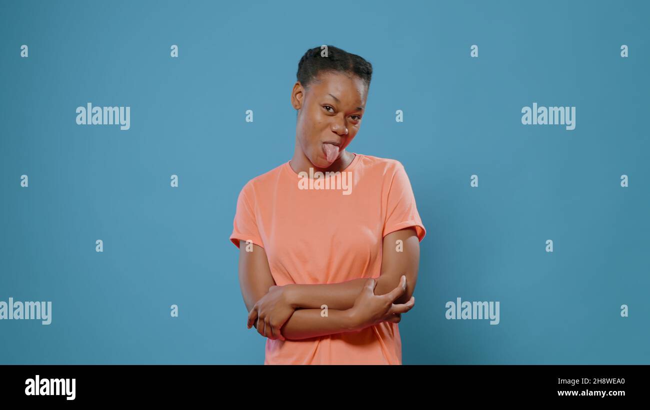 Playful woman sticking tongue out in front of camera. Foolish person ...