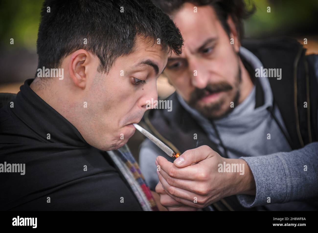Man lighting up a joint a marihuana or hashish joint cigarette. Closeup ...