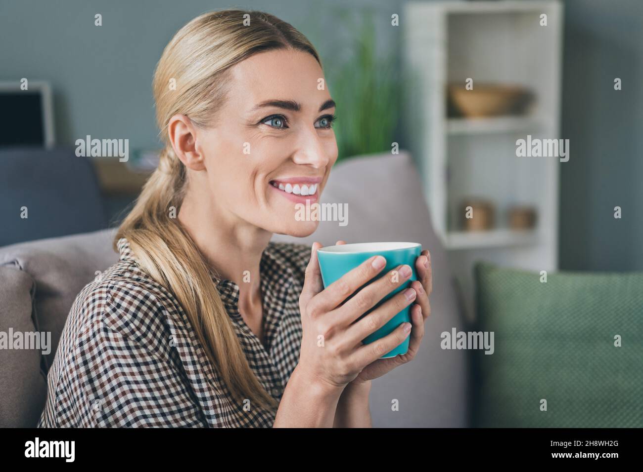 Photo of positive cheerful lady sit comfy divan enjoy drink arabica ...