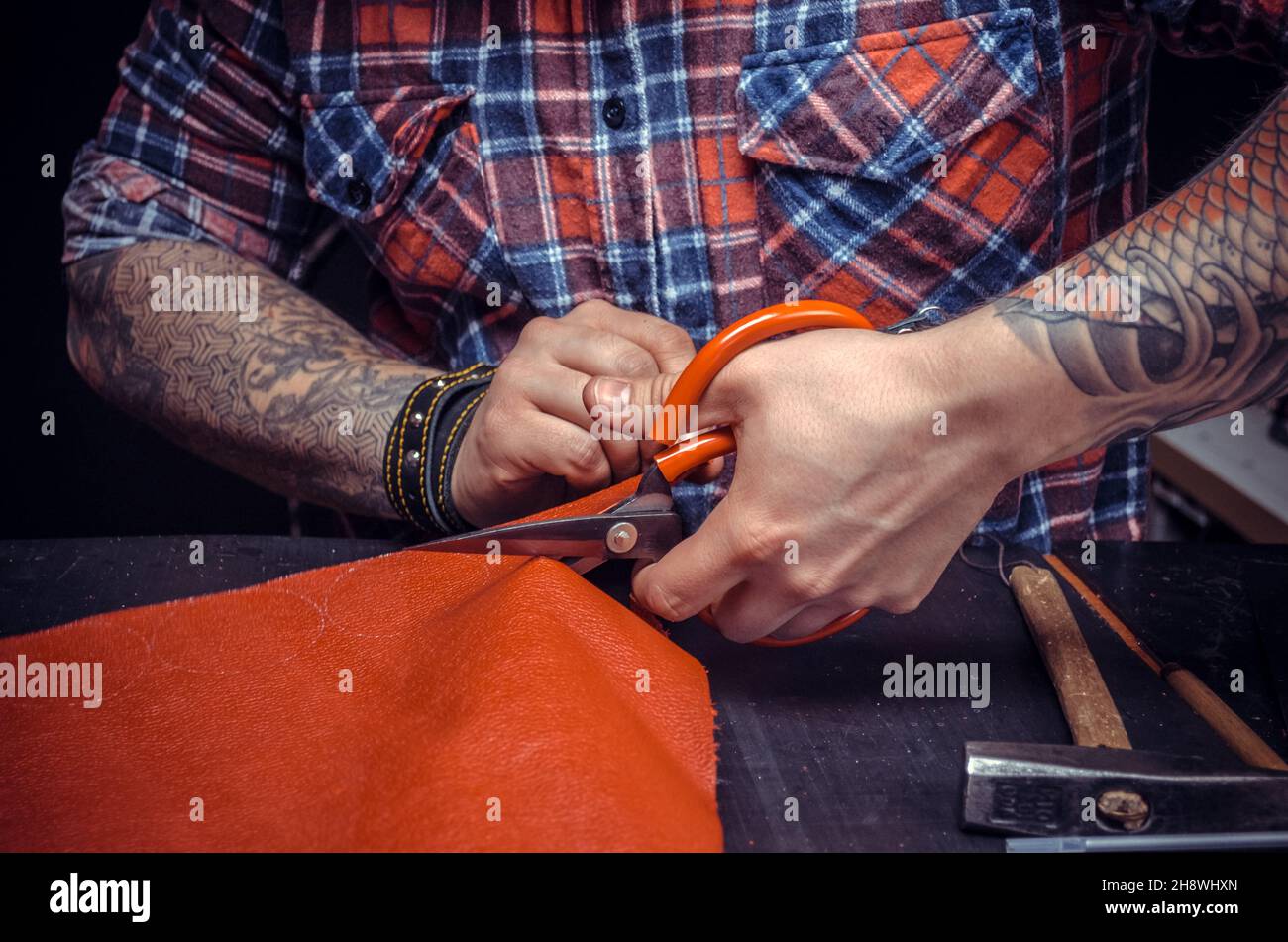 Leather Artisan cutting out leather goods in his leather studio Stock ...