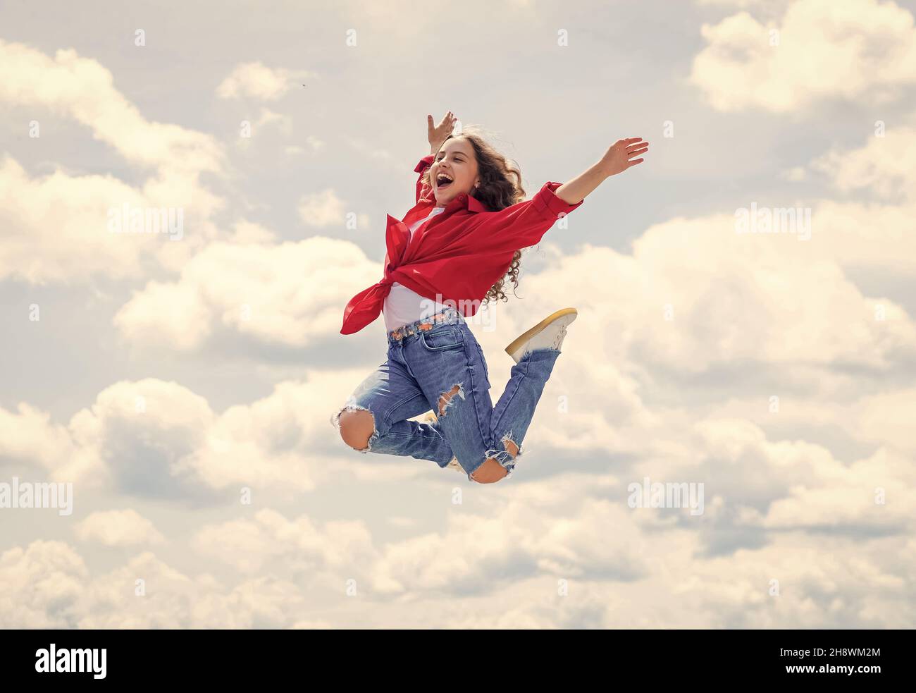 smiling child jumping so high. carefree and joyful. kid fashion style ...