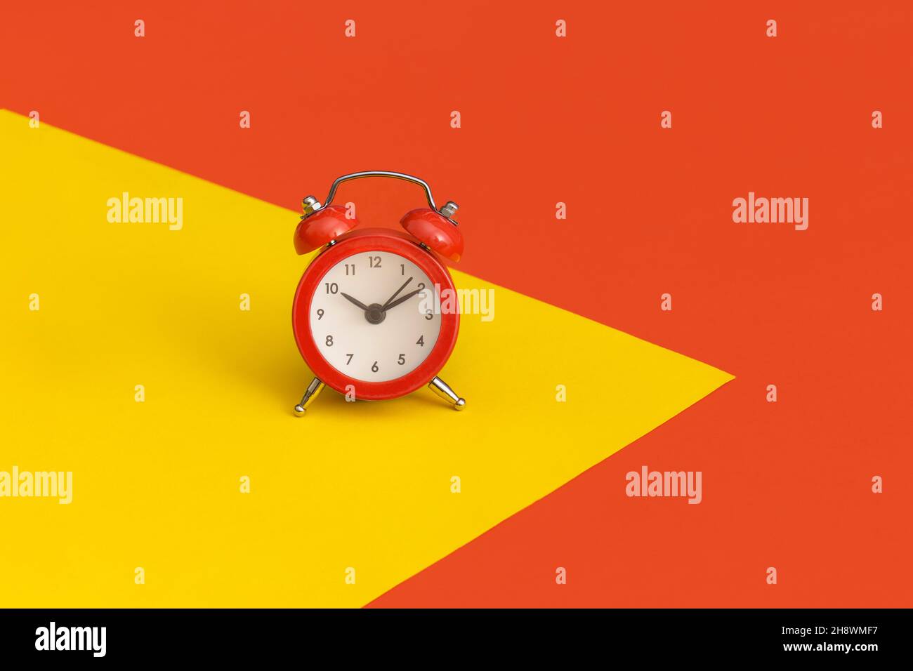 Red alarm clock on color background Stock Photo - Alamy
